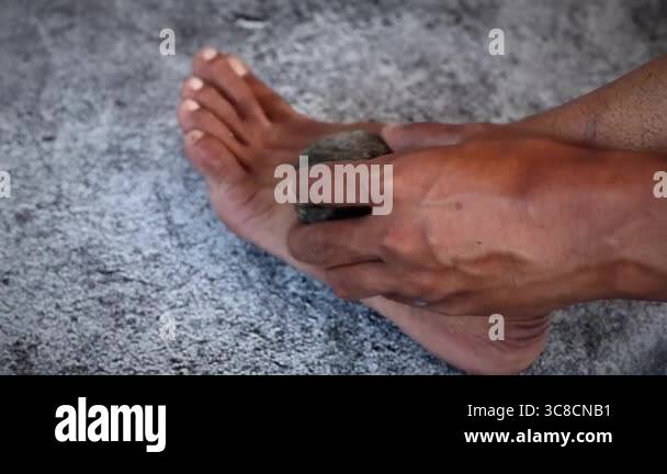 Close up scrub feet by grey spa stone isolated on grey background with ...