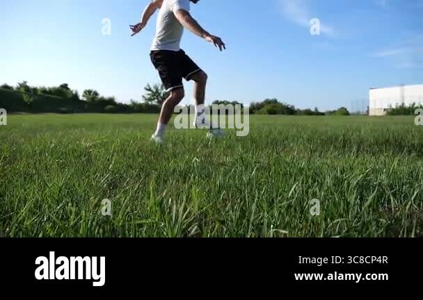 Professional footballer in uniform shows tricks with ball while running ...