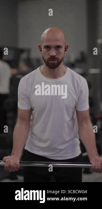 Bald man with beard lifts weights at the gym Stock Video Footage - Alamy