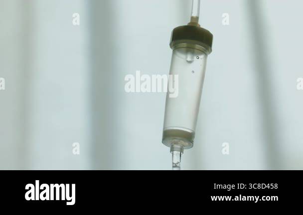 Close-up of an intravenous drip chamber with liquid drops, symbolizing ...