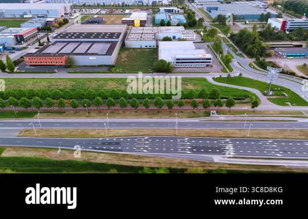 Flying along the road near industrial area. Low-rise large buildings ...
