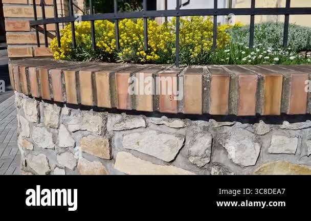 Retaining wall next to the house with a metal lattice fence. The ...