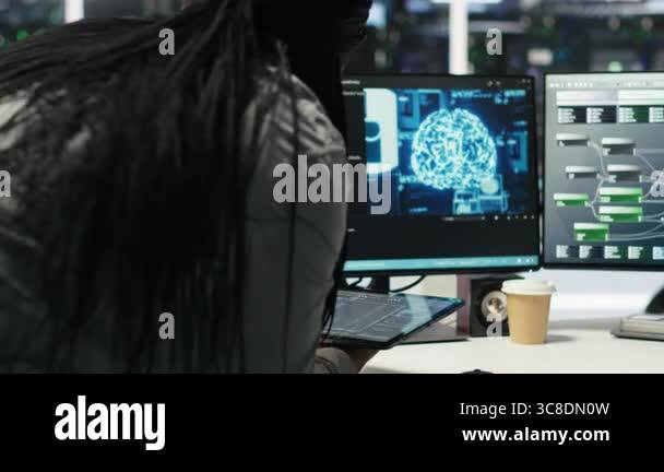 Data center engineer in wheelchair and colleague oversee automated tasks using node tree ...