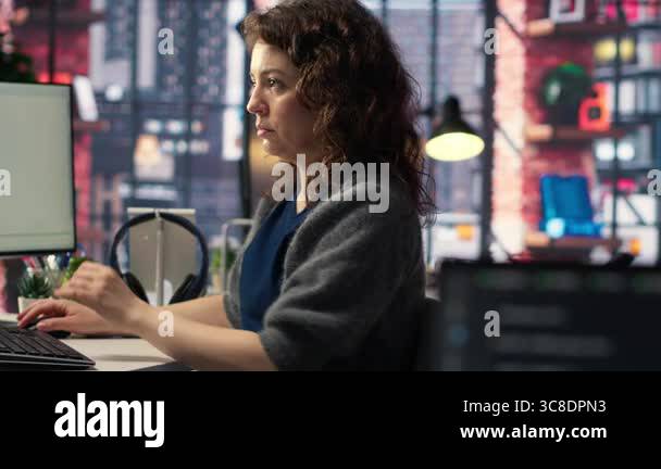 Young woman programming software code on her computer, using coding language for debugging tasks ...