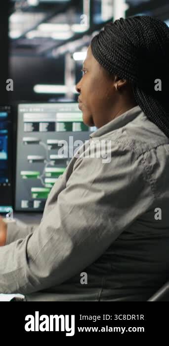 Vertical video Data center employee deploying AI solutions optimizing equipment. Server farm ...