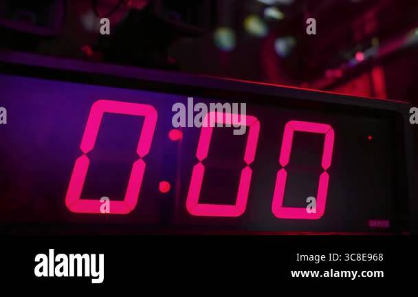A bright red countdown clock shows zero at an energetic event Colorful lights and an engaging ...