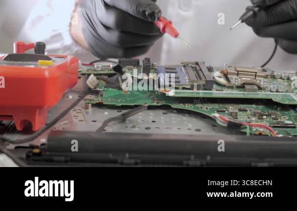 Testing motherboard with probes and multimeter, Close-up of technician ...
