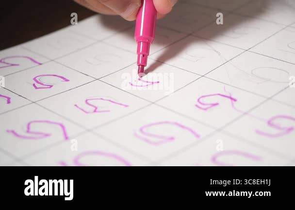 Hands are using bright markers to practice writing letters and numbers ...
