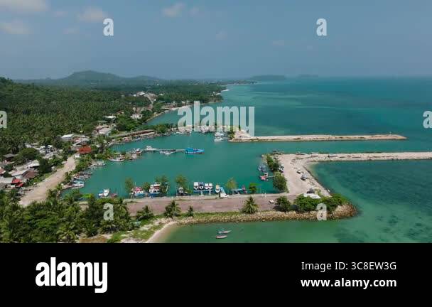 Small marina with boats, turquoise waters, and lush green surroundings ...