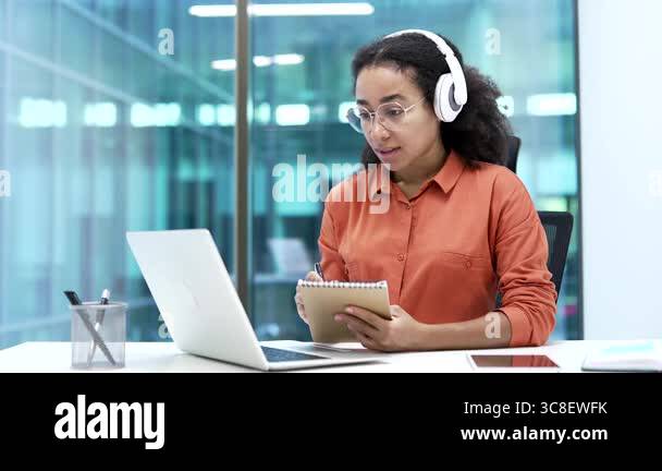African american businesswoman in headphones watching video call online ...