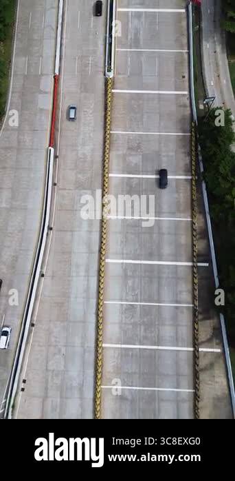 Overhead shot of cars driving on a highway. Concrete road, yellow and ...