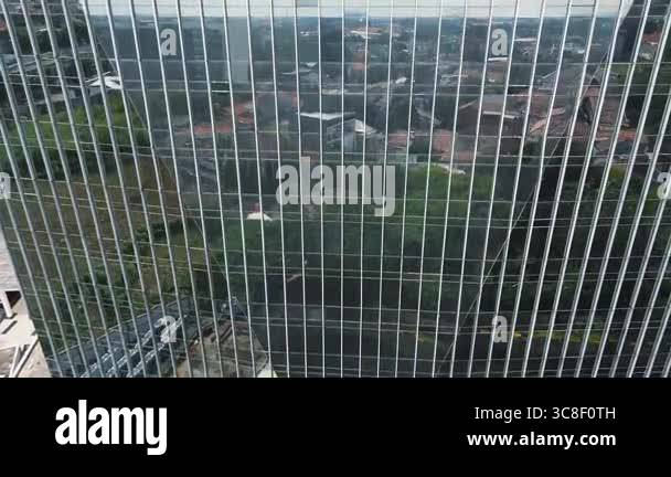 Drone footage of a modern glass skyscraper reflecting a city ...