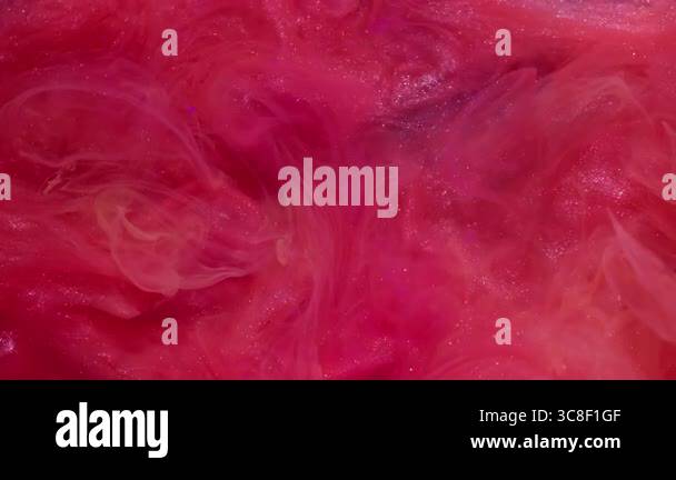Shimmering dust. Powder flow. Bright art ink in liquid. Haze red orange ...