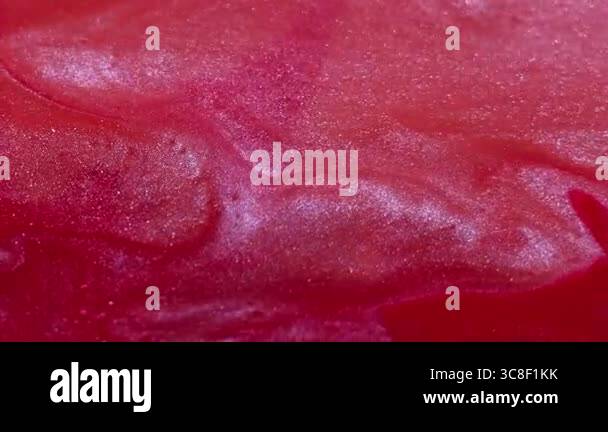Shiny emulsion. Sparkling liquid. Defocused red crimson colorful paint ...