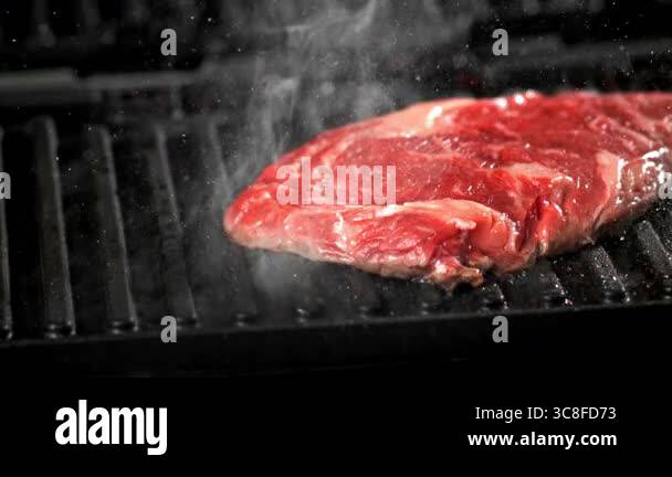 Beef ribeye steak is grilled. Filmed on a high-speed camera at 1000 fps ...