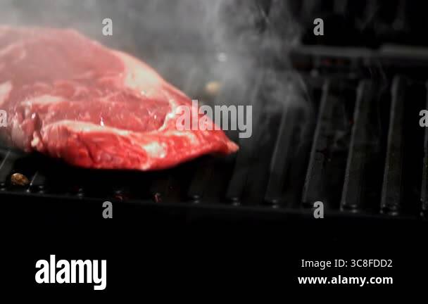 The ribeye steak falls into the pan. Filmed on a high-speed camera at ...