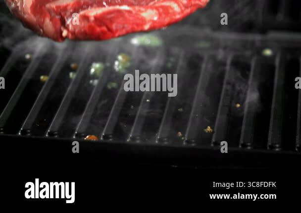 The ribeye steak falls into the pan. Filmed on a high-speed camera at ...