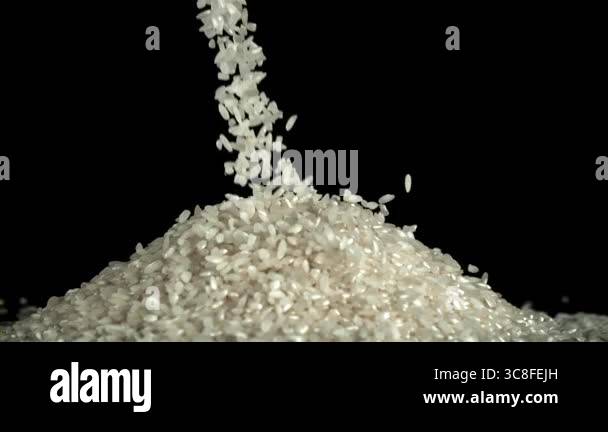 Rice falling on a black background. Filmed on a high-speed camera at ...