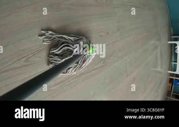 Thorough cleaning of the house, close-up of a mop washing a laminate ...