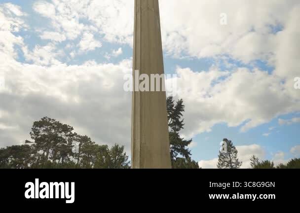 Ground-up view of imposing concrete pillars rising into a partly cloudy ...