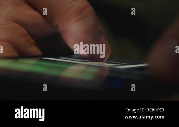 A person's hand scrolls through chat conversations on a mobile phone ...