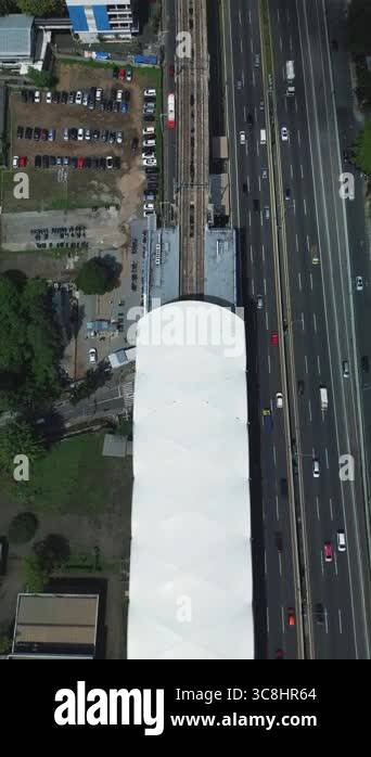 Overhead view of an MRT station, train tracks, and busy highway with ...