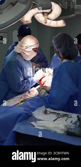 Experienced surgeons in blue coats operate on a military patient in a ...