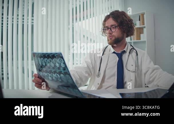 A Doctor Works, Analyzing X-rays and CT Scans on a Computer Screen He ...