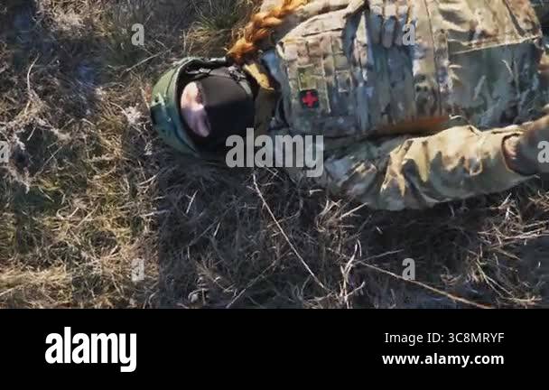 Female military medic of ukrainian army lying on dry grass at meadow ...