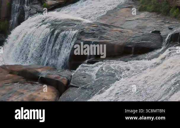 Refreshing water flows over rocks, creating soothing atmosphere in lush ...