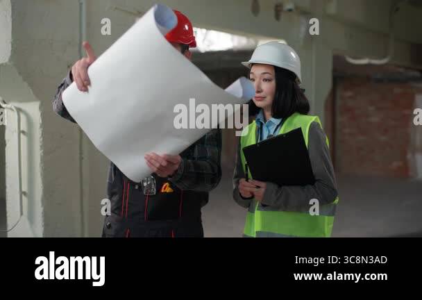 Two diverse Caucasian Japanese builders contractors man woman civil ...