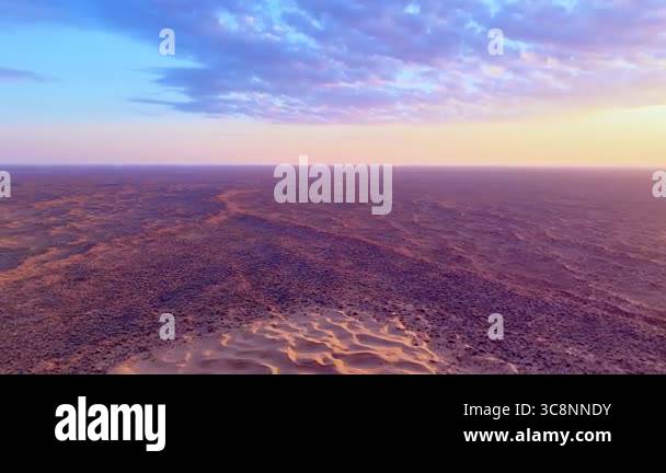Wide desert view at sunrise with dunes and sparse bushes. The pastel ...