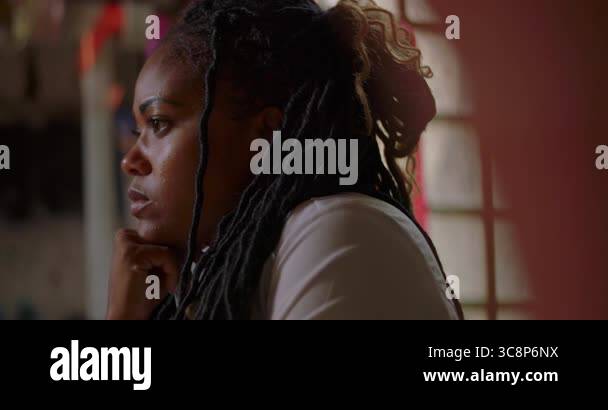 Focused African American woman deep in thought, resting chin on hand ...