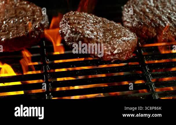 Slow Motion of Various BBQ Meat on a Grill with Roaring Flames . Camera ...