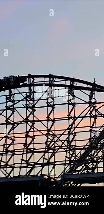 Silhouetted Roller Coaster at Sunset, A thrilling wooden roller coaster ...