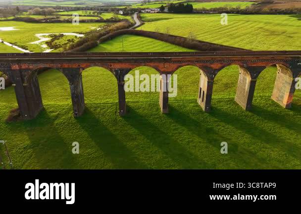 Elevated railway viaduct arching over green countryside with long ...