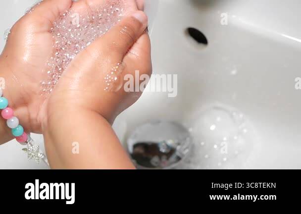 A child learns proper hand washing techniques using soap and water ...