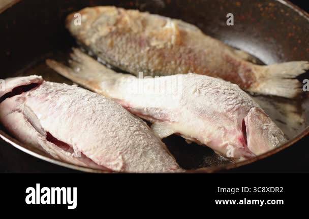 Home cooking. River fish crucian carp is fried in a frying pan in ...