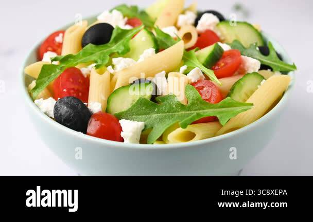 Rotating mediterranean Pasta salad in bowl with Fresh Vegetables and ...