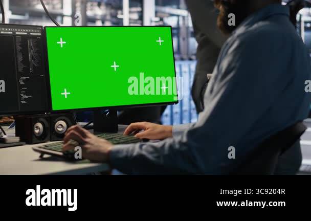 Close up of data center technician using green screen PC to monitor neural network AI. Server ...