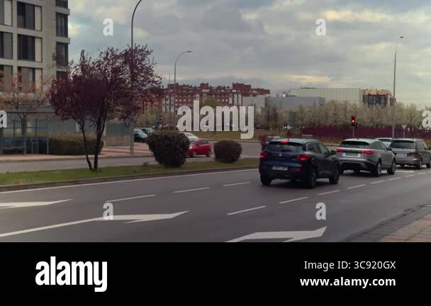 Multiple cars driving on an urban road approaching an intersection ...