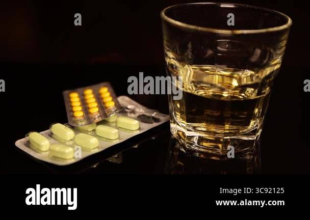 medication next to a glass of alcohol, addiction treatment, harm to ...