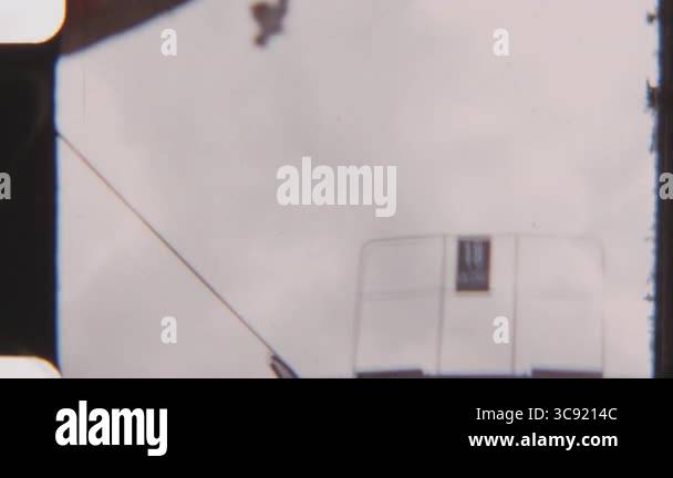 Vintage 8mm POV shot from a moving chairlift looking upward at a sign ...