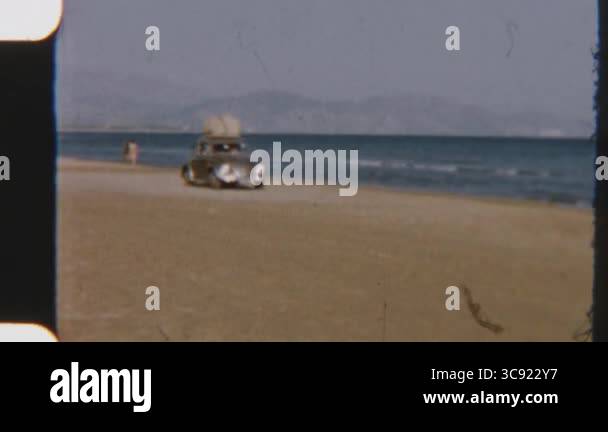 A classic VW Beetle cruises along the sandy Terracina coastline ...