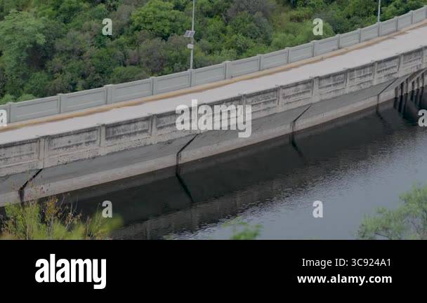 Concrete dam with calm water and surrounding forest. High quality 4k ...