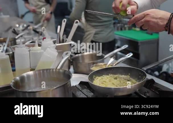 Professional chef working in a commercial kitchen preparing a meal with ...