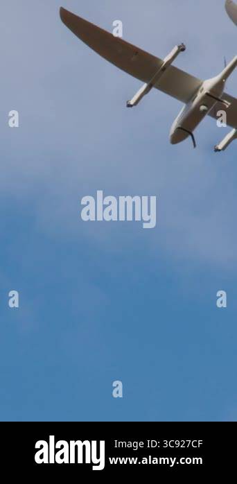 White smart drone in the shape of an airplane flies and films in the ...