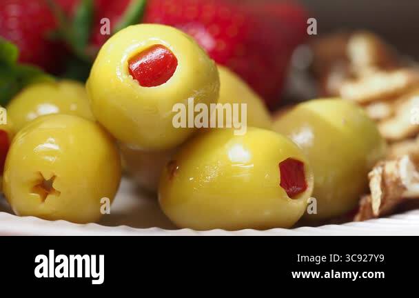 Green olives with pimento filling arranged on a plate, perfect for ...