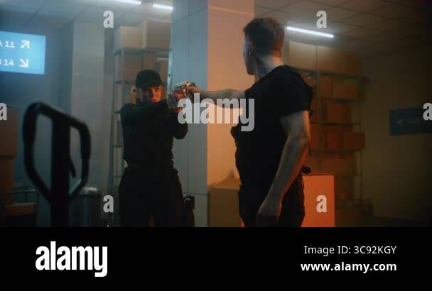 Armed Confrontation: Man and Woman in Tactical Gear Aiming Guns at Each ...