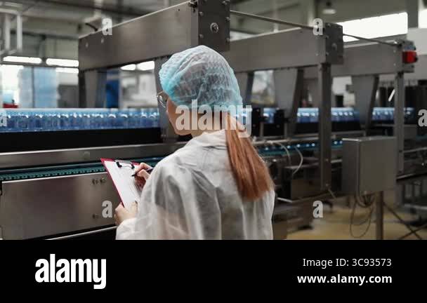 Female quality control inspector wearing protective clothing and mask ...